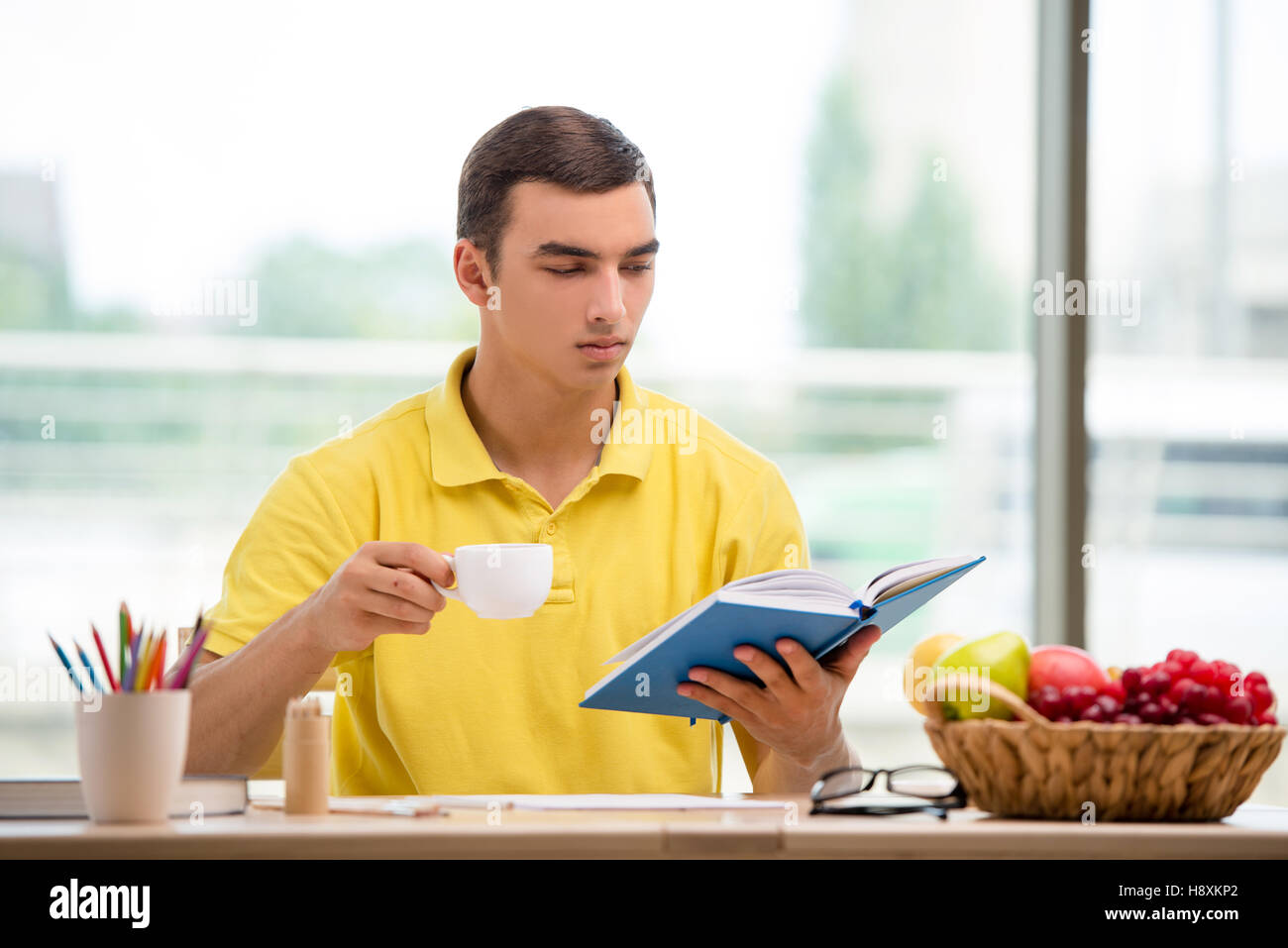 Student reading book and drinking tea Stock Photo - Alamy
