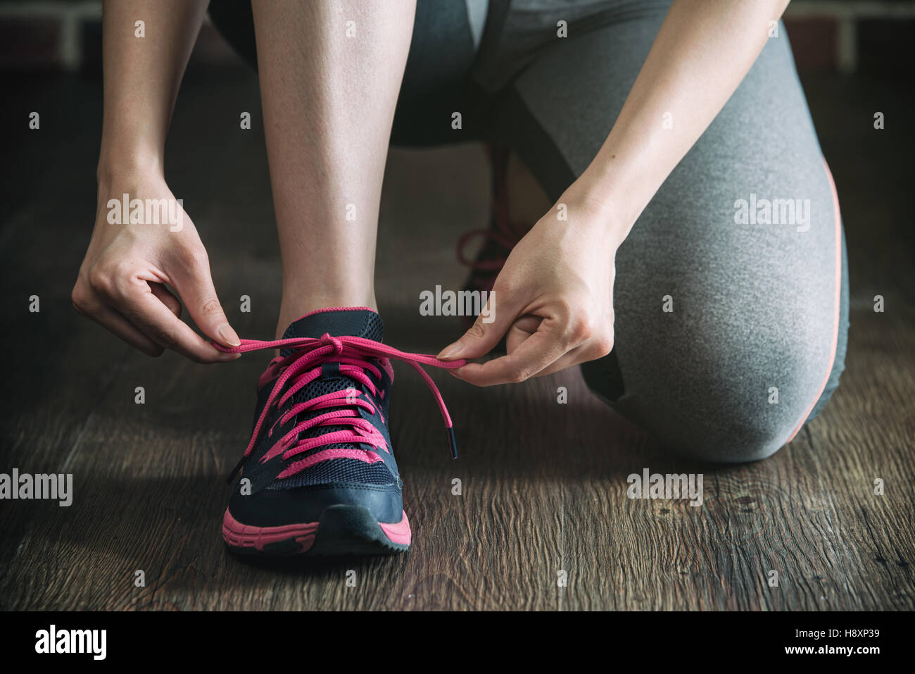 knee down with tie sneakers shoestring before fitness exercise, gym ...
