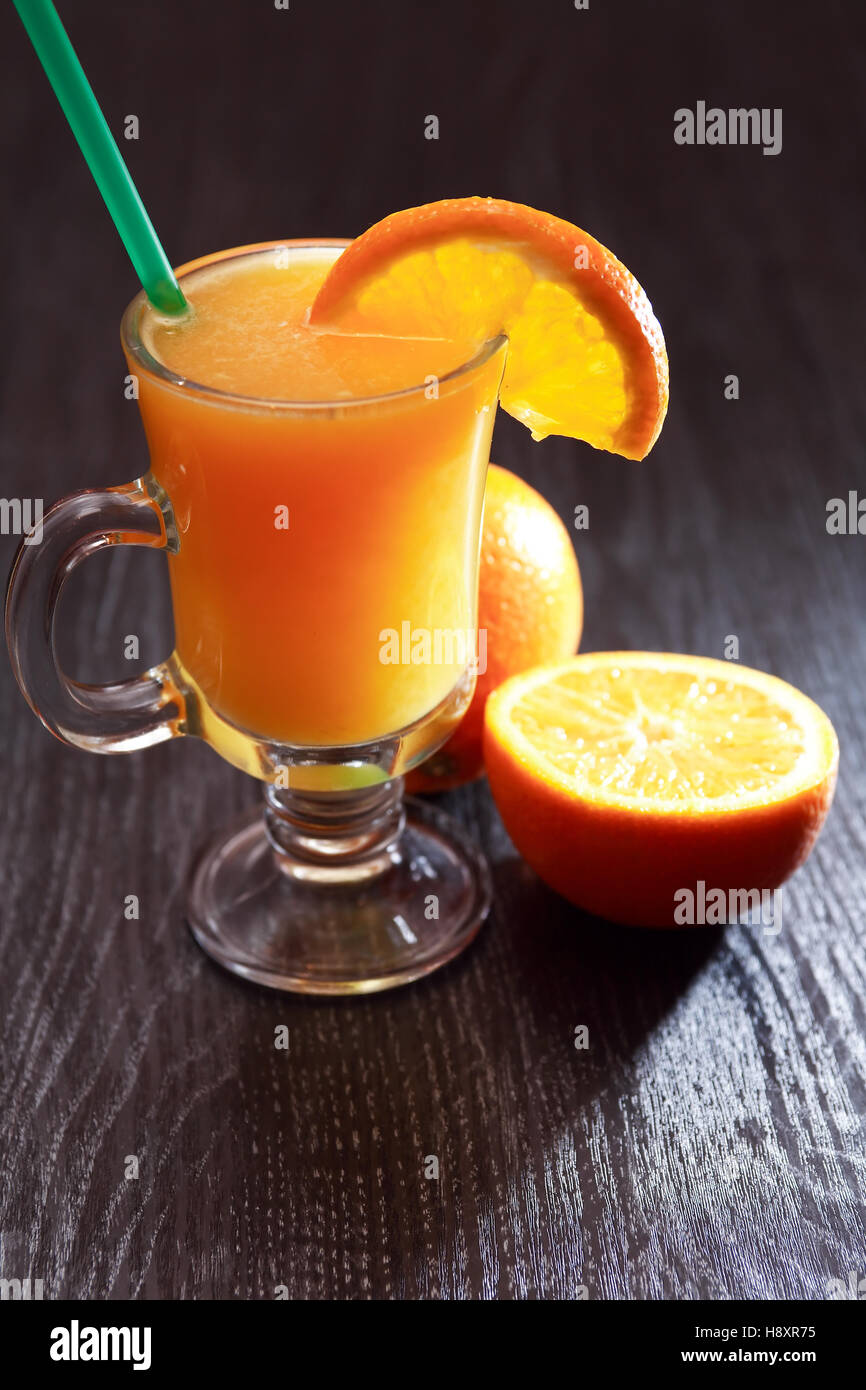 Nice goblet full of orange juice near fruits on table Stock Photo - Alamy