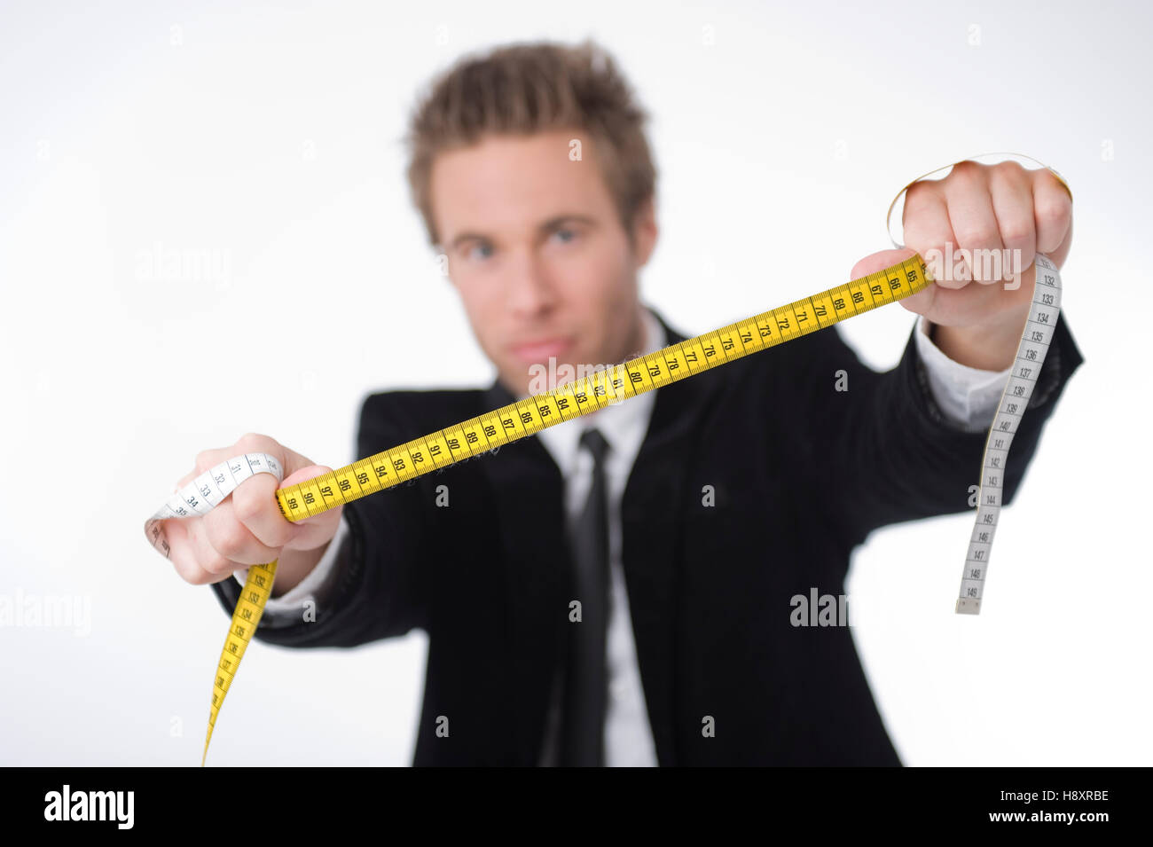 Businessman holding a measuring tape Stock Photo - Alamy