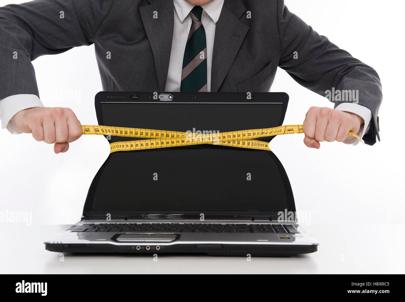 Business man tying up his laptop with measuring tape Stock Photo - Alamy