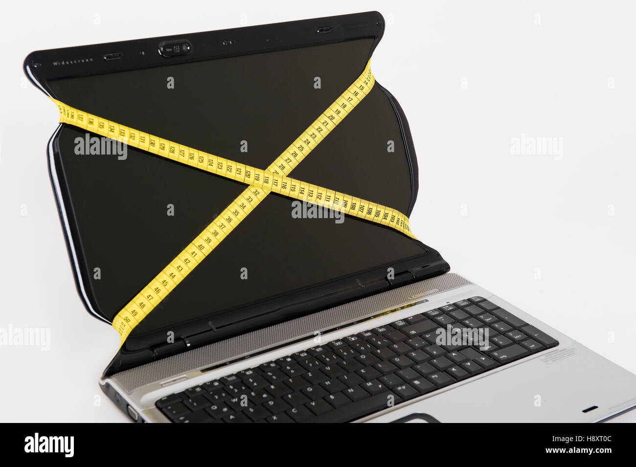 Small laptop, tied up with measuring tape Stock Photo - Alamy