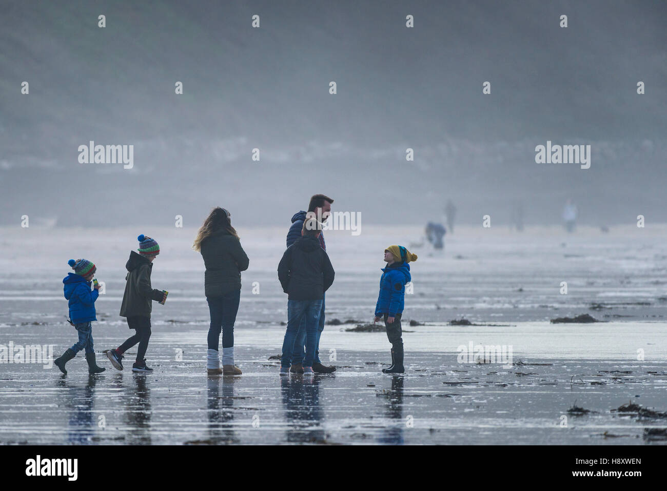 A family on Fistral Beach on a cold day in Newquay, Cornwall Stock ...