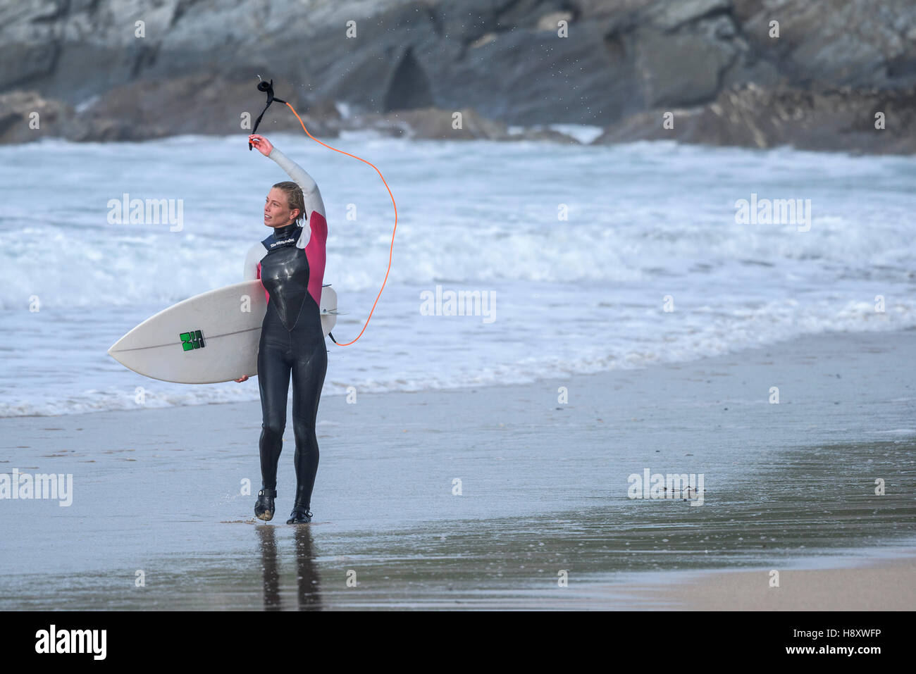 A female surfer walks along Fistral Beach in Newquay, Cornwall Stock ...