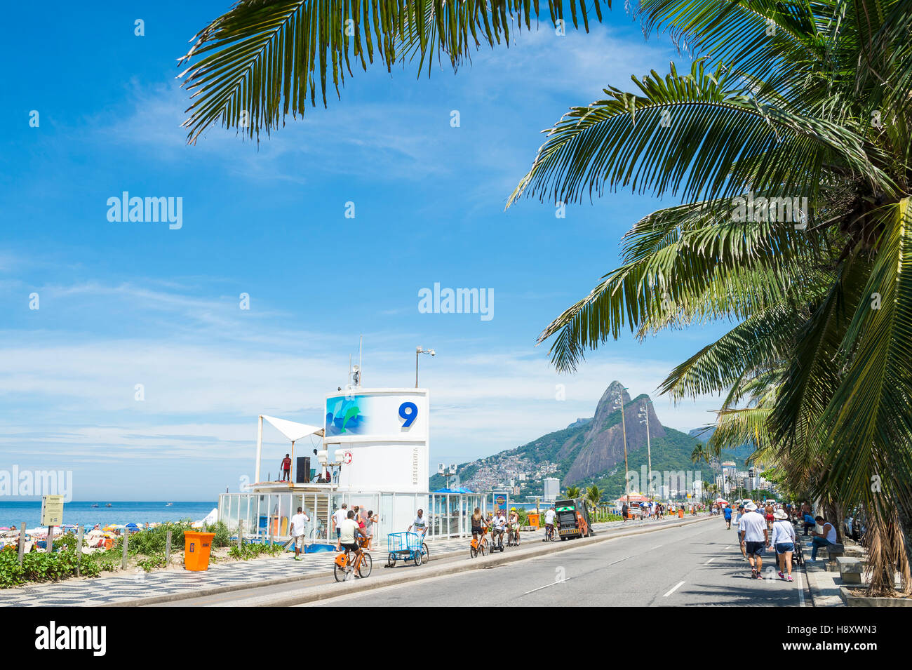 RIO DE JANEIRO - FEBRUARY 28, 2016: Beachgoers stroll with active ...