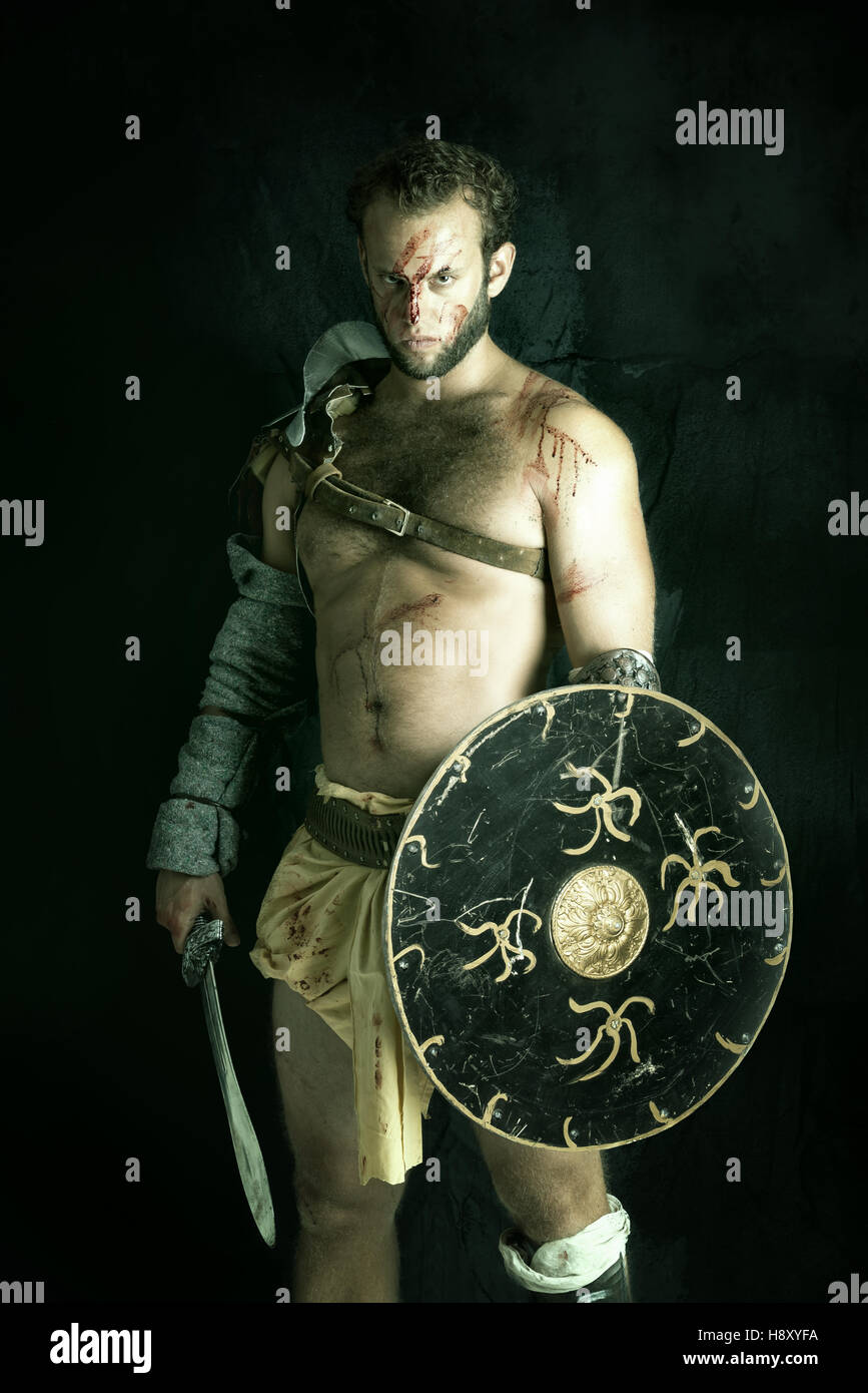 Ancient warrior or Gladiator posing against a dark background with ...