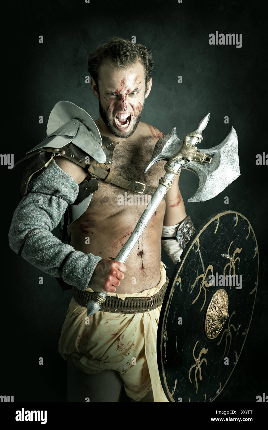 Ancient warrior or Gladiator posing against a dark background with an ...