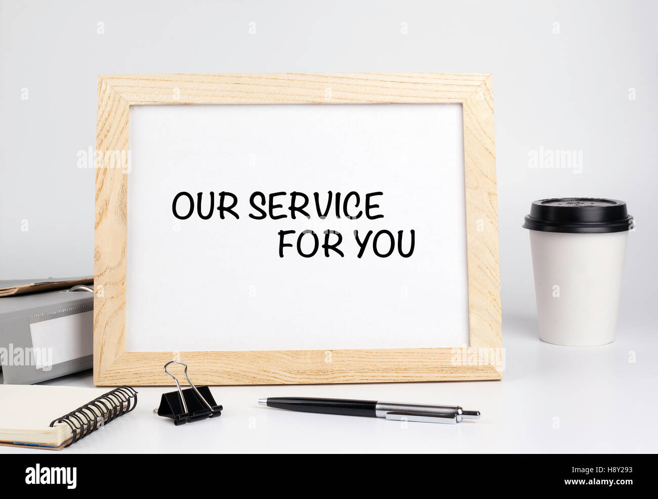 Office table with wooden frame with text - Our Service For You Stock ...