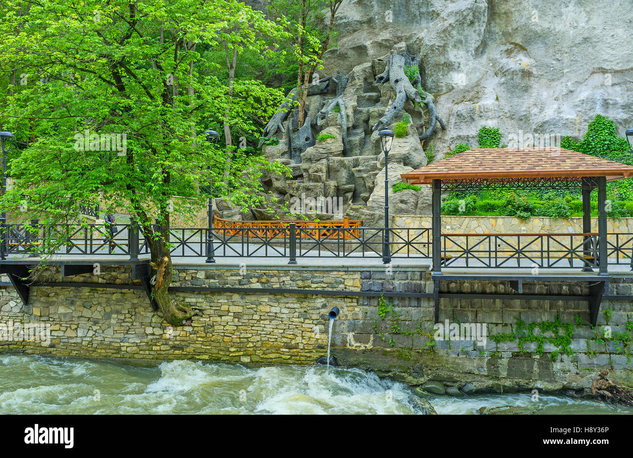 The embankment of Borjomula river with the small alcove for tourists ...