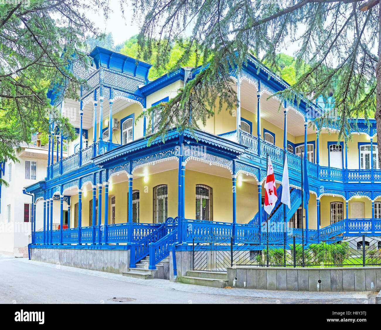 The old mansion with deep blue wooden terraces, decorated with carved ...