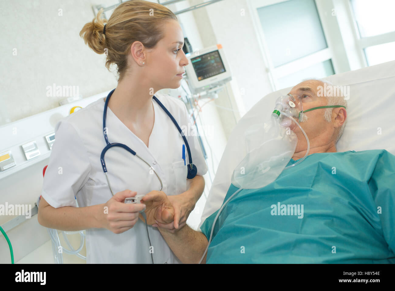 young doctor assisting an old patient Stock Photo - Alamy