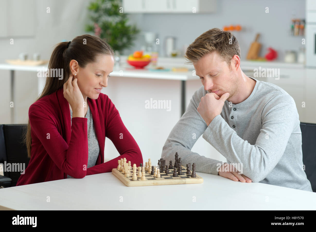 happy young couple playing chess in living room Stock Photo - Alamy