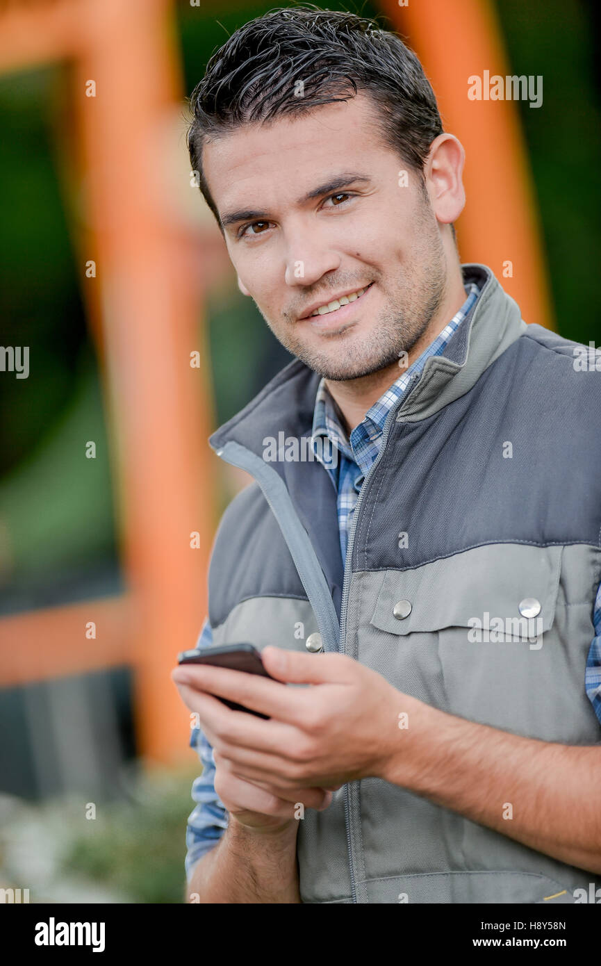 Man outdoors holding mobile telephone Stock Photo - Alamy