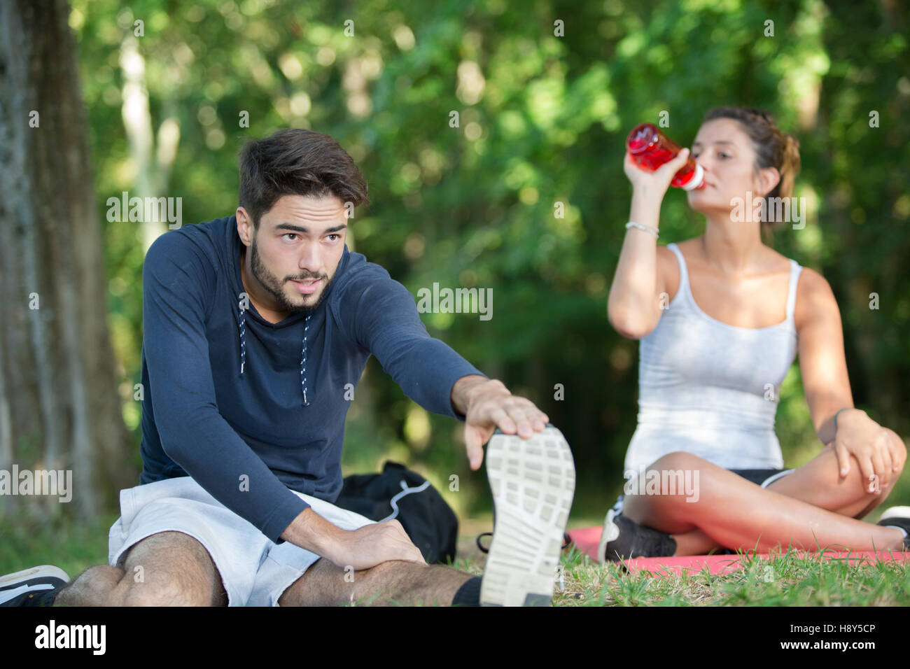 couple stretching outdoors while drinking water Stock Photo - Alamy