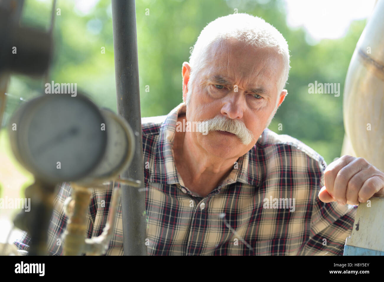 old-man outdoors checking machine Stock Photo - Alamy
