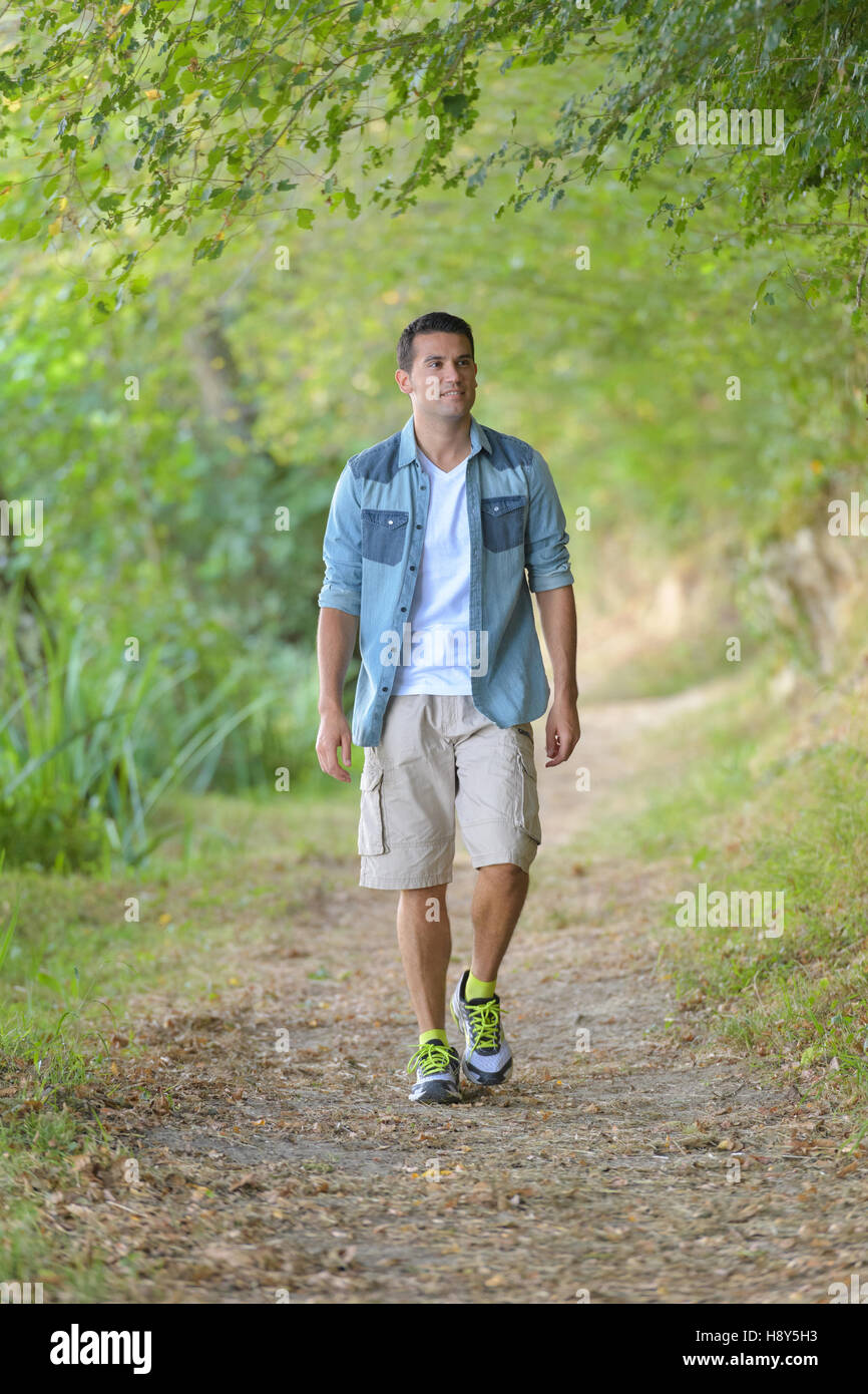 handsome man walking on forest path Stock Photo - Alamy