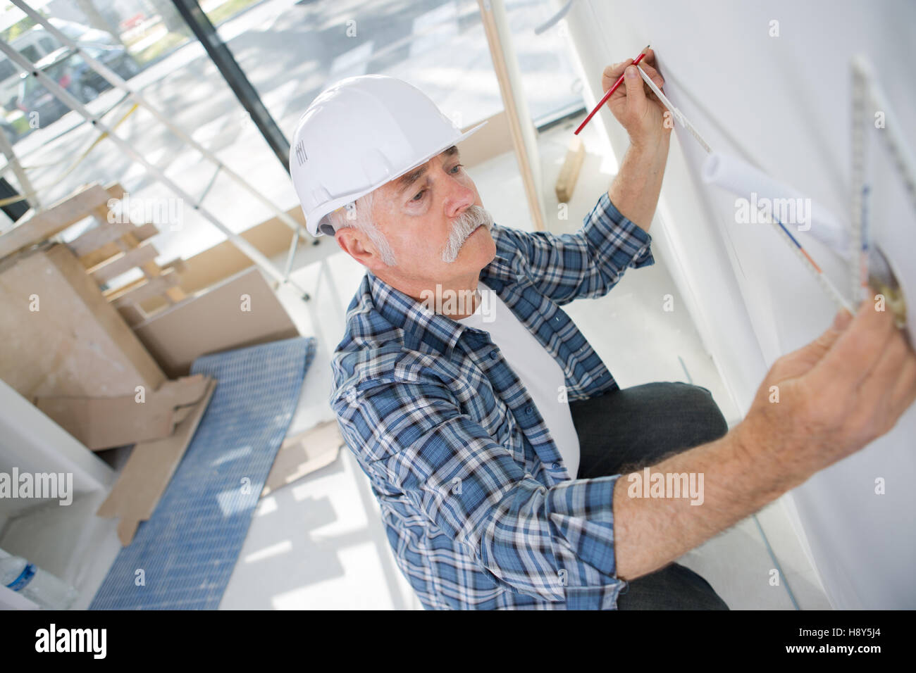 old construction worker measuring the wall Stock Photo - Alamy