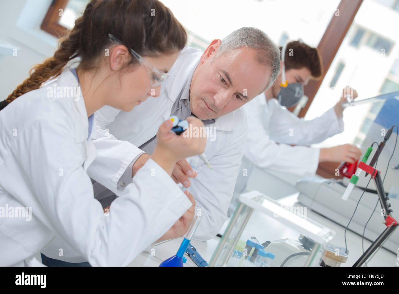 young woman apprentice testing in a lab Stock Photo - Alamy