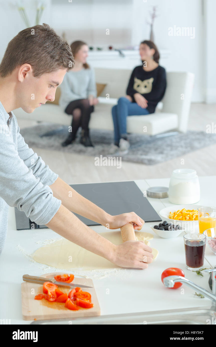 a young man making a pastry for friends Stock Photo - Alamy