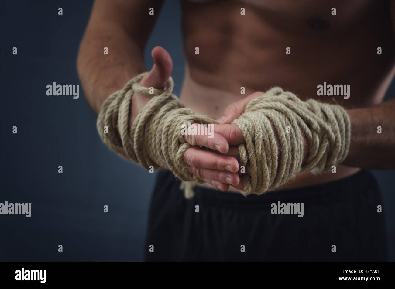 Close-up of a young Thai boxer hands hemp ropes are wrapped before the ...