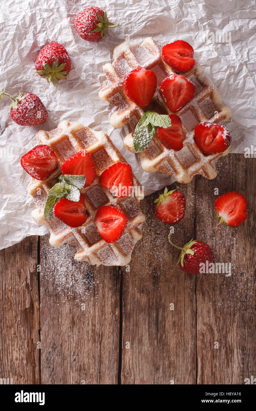Belgian waffles with strawberries and powdered sugar close-up on the ...