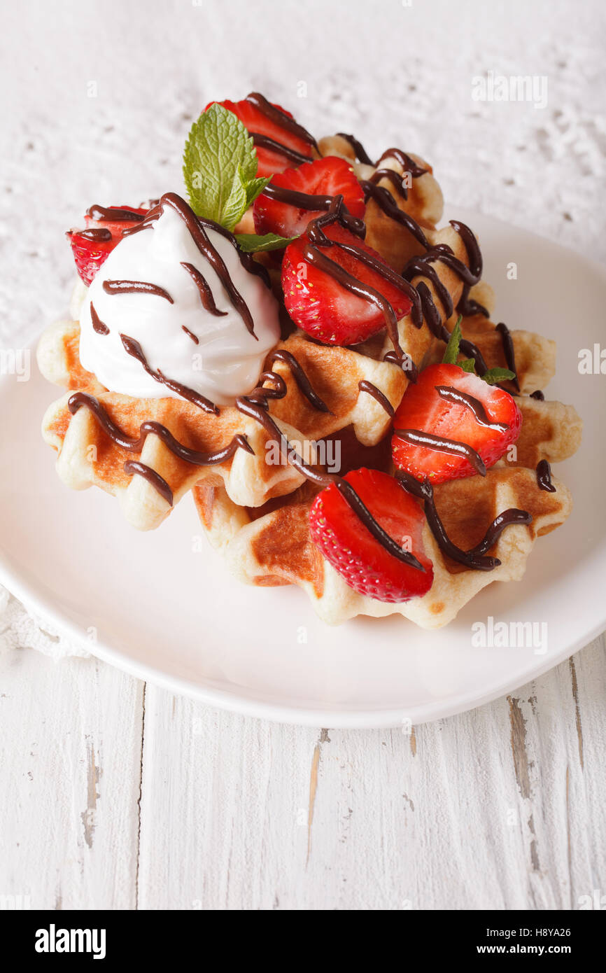 Belgian waffles with strawberries, whipped cream and chocolate close-up ...