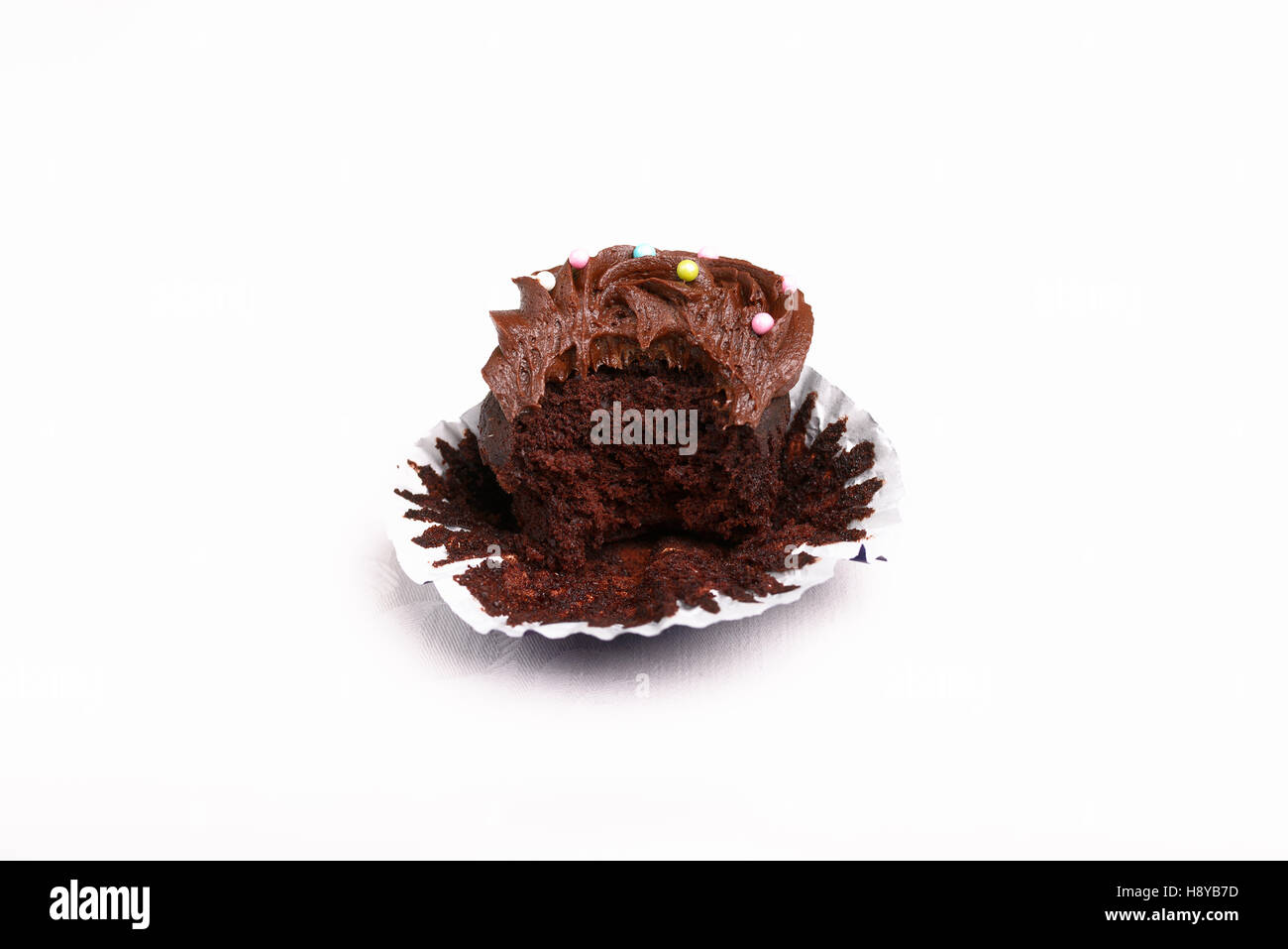 Delicious chocolate fairy cake bitten into, isolated on white ...