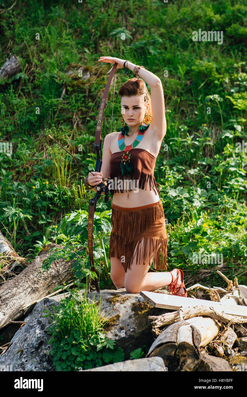 The young beautiful girl amazon aiming a bow while hunting in the ...