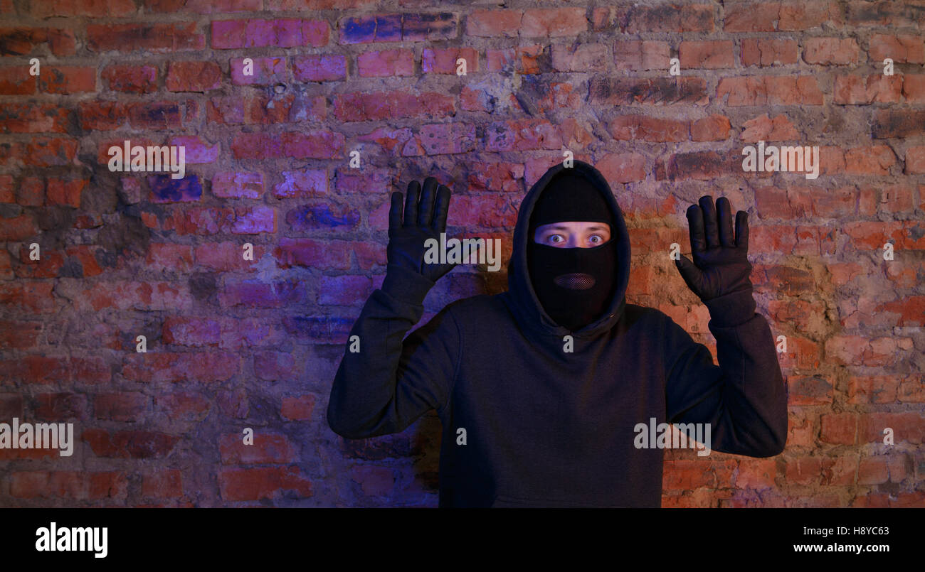 Caught burglar standing near wall Stock Photo - Alamy