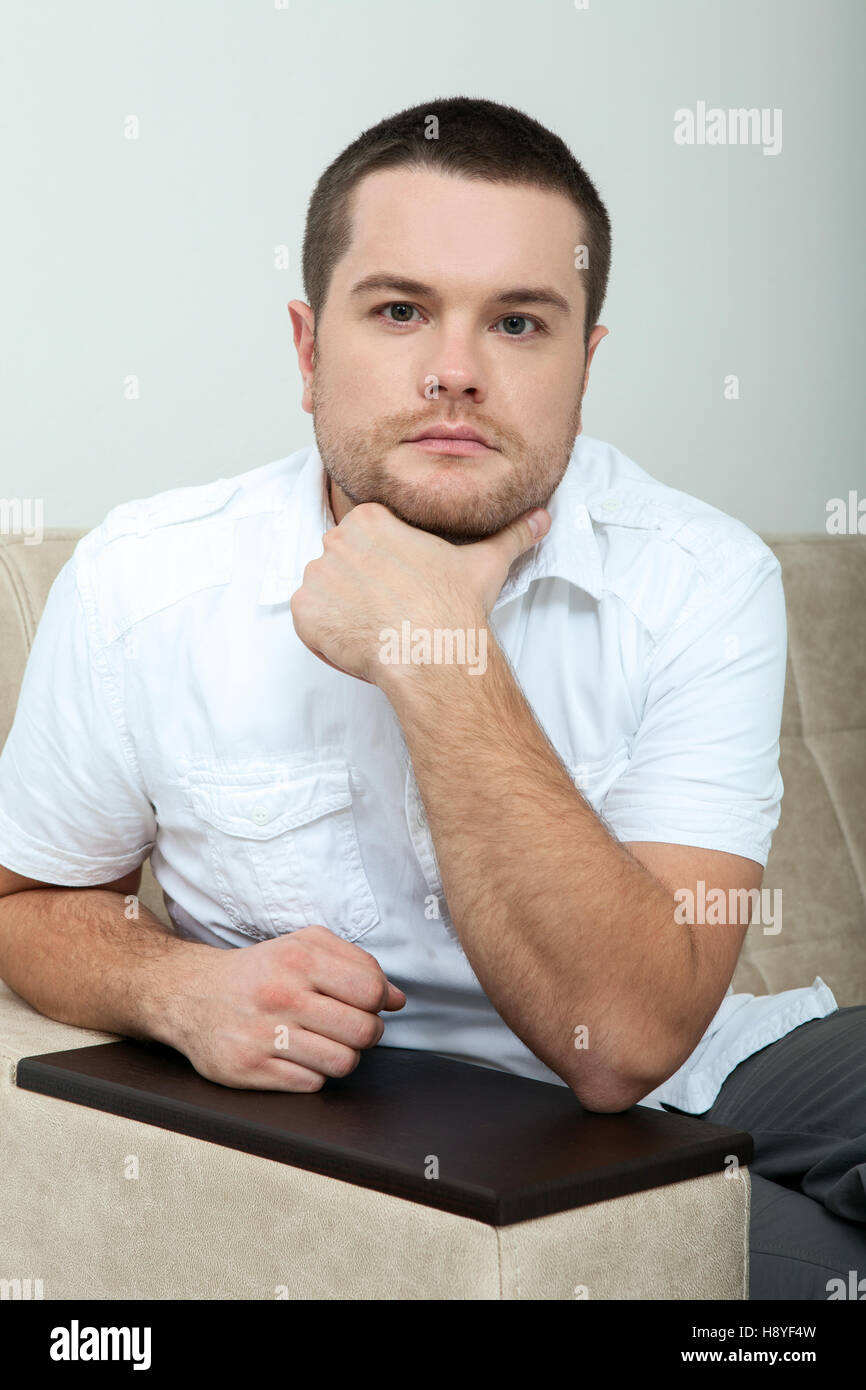 Man having restful moment relaxing while sitting against wall in an ...