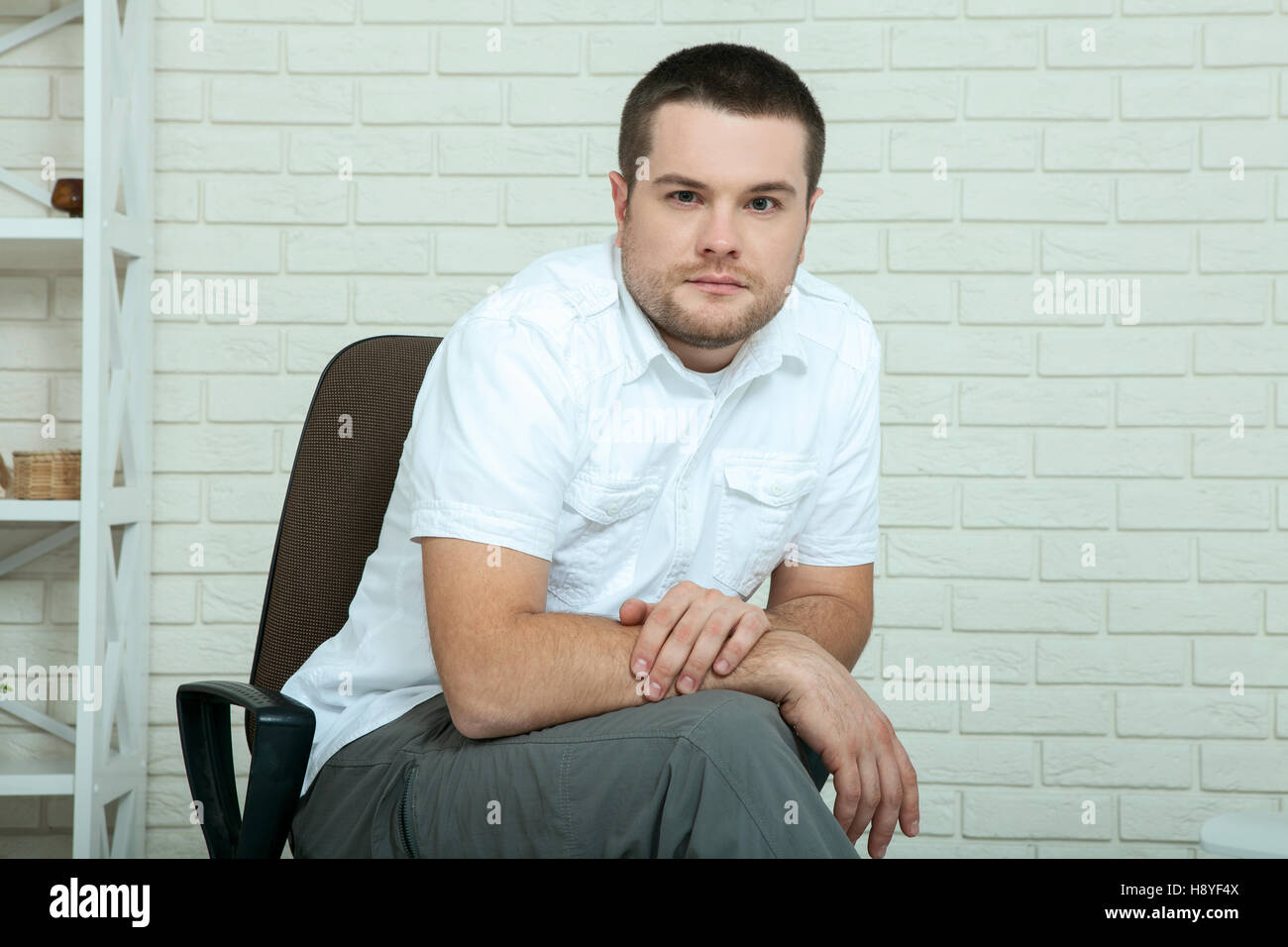 Man having restful moment relaxing while sitting against wall in an ...
