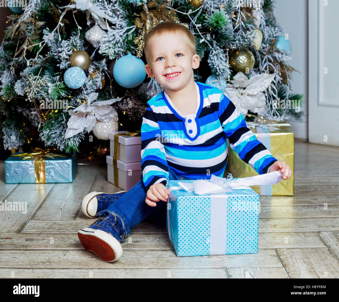 happy child at home with Christmas tree and presents Stock Photo - Alamy