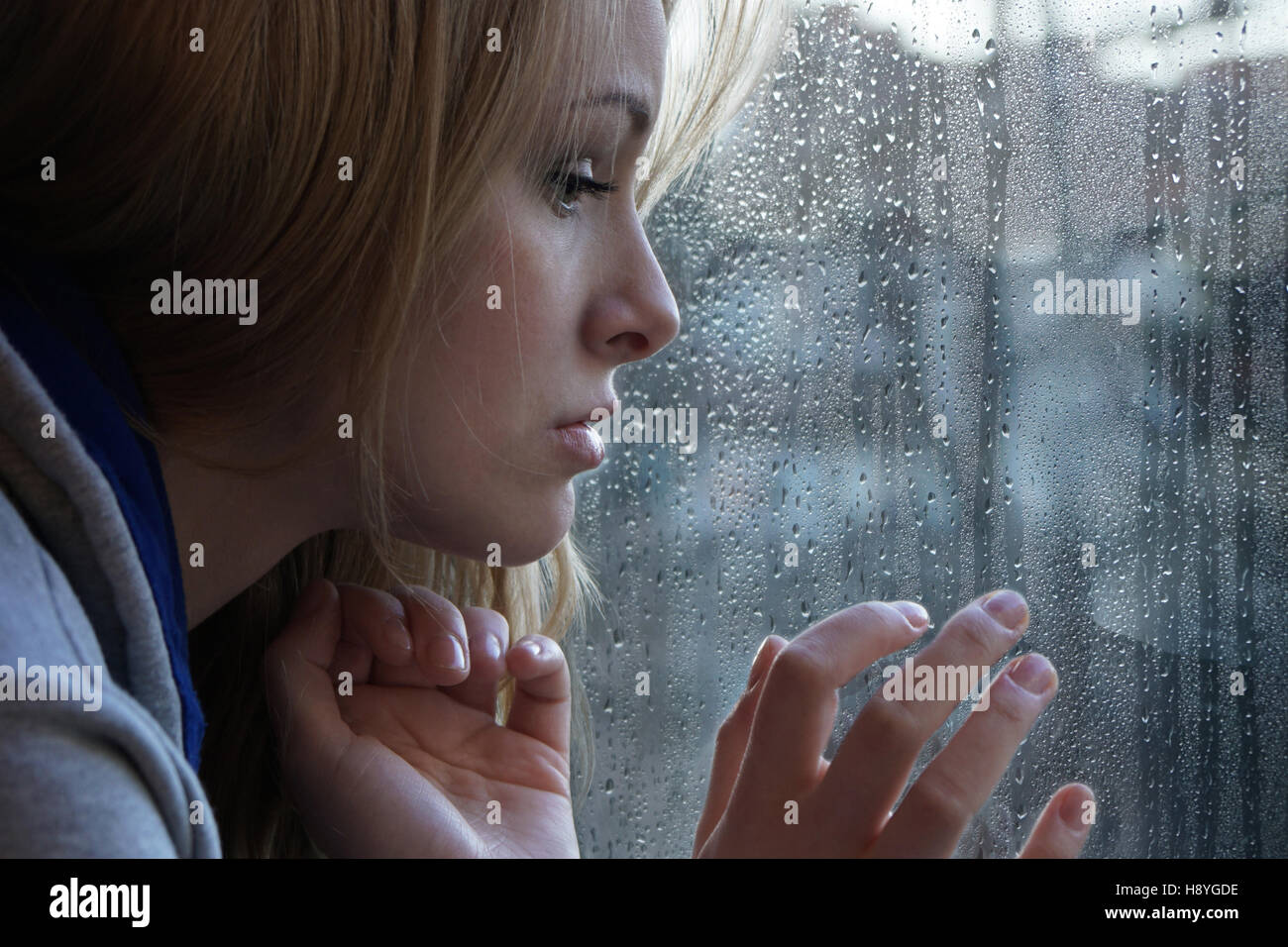 Sad young woman window hi-res stock photography and images - Alamy