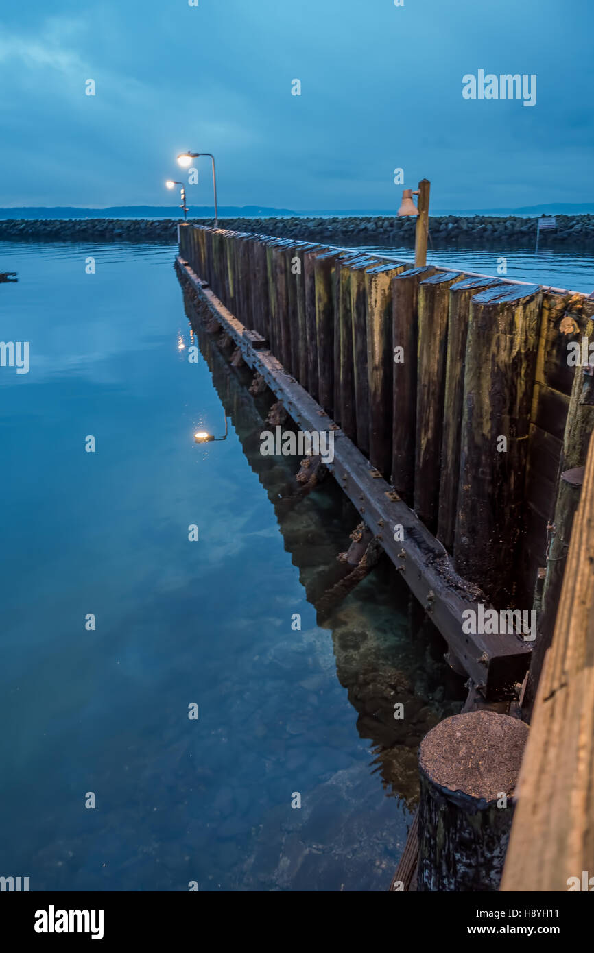 A wall of wooden posts juts out at Des Moines Marina as darkness falls ...