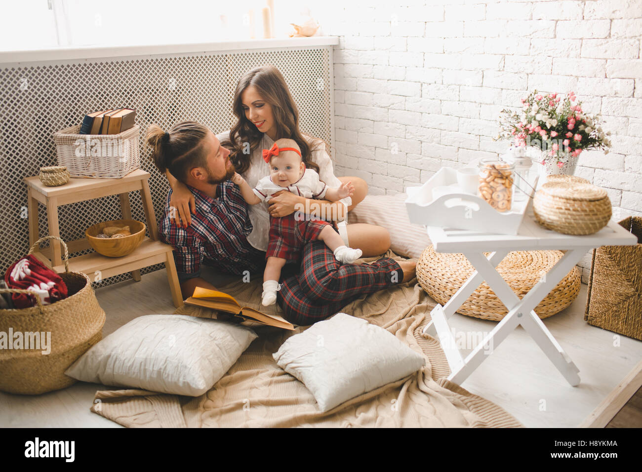 Young family reading story indoors Stock Photo - Alamy