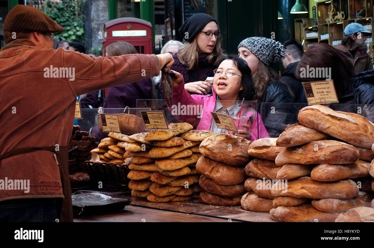 Customers buy bread at a bread stall in Borough Market, London, Britain ...