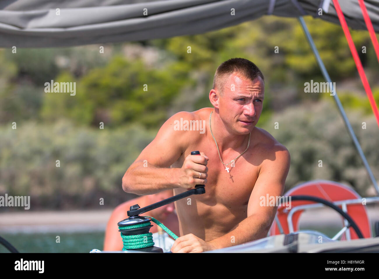 Man skipper turns rope at sailing boat on the Sea. Luxury yacht Stock ...