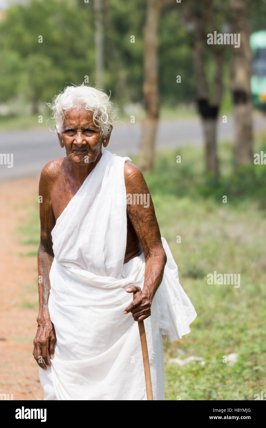 Old lady, a widow dressed in white along street Stock Photo - Alamy