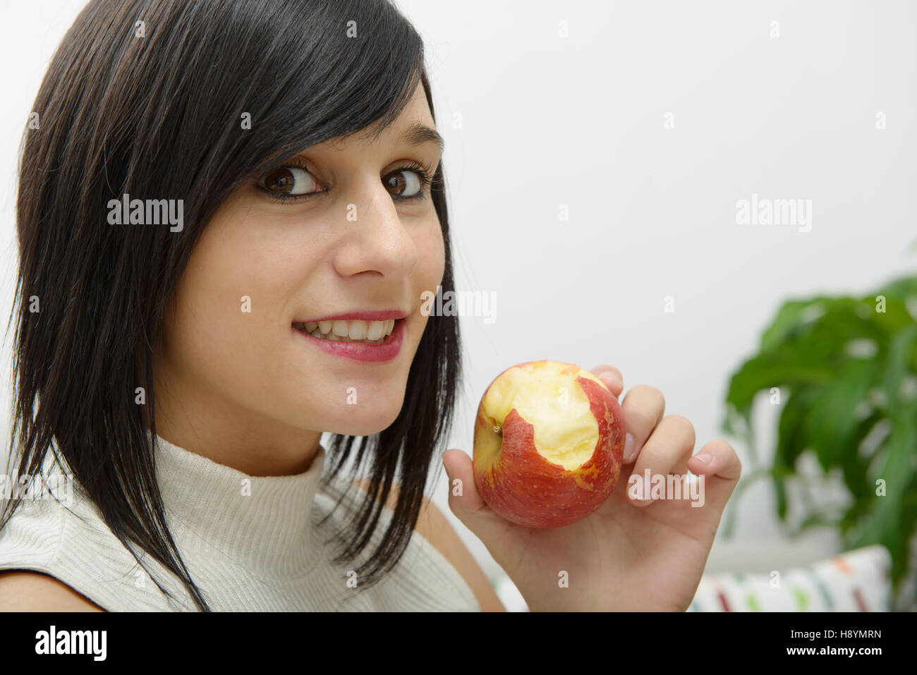 young woman eating an apple in home Stock Photo - Alamy