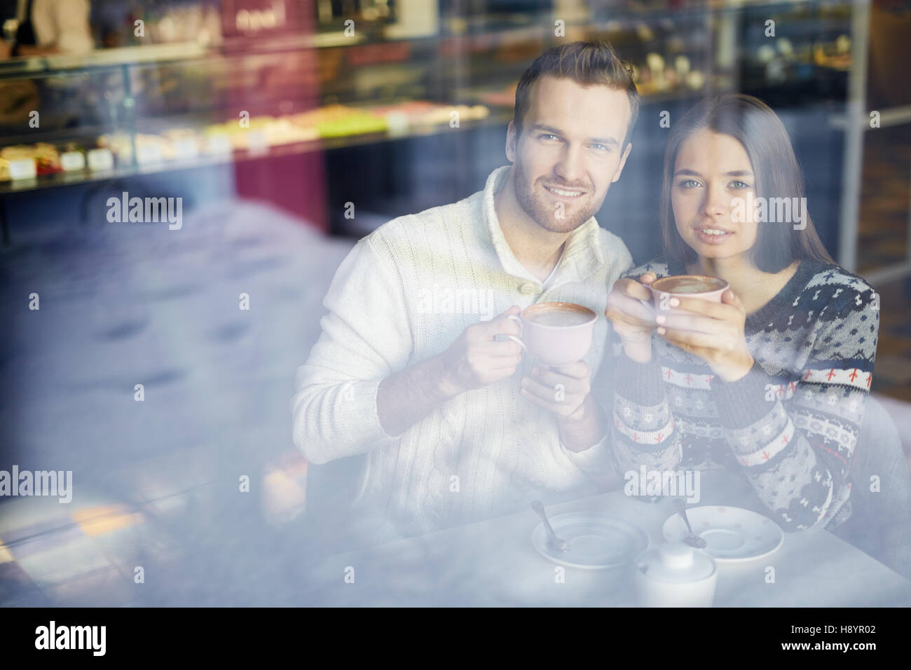 Restful couple having hot coffee in cafe Stock Photo - Alamy