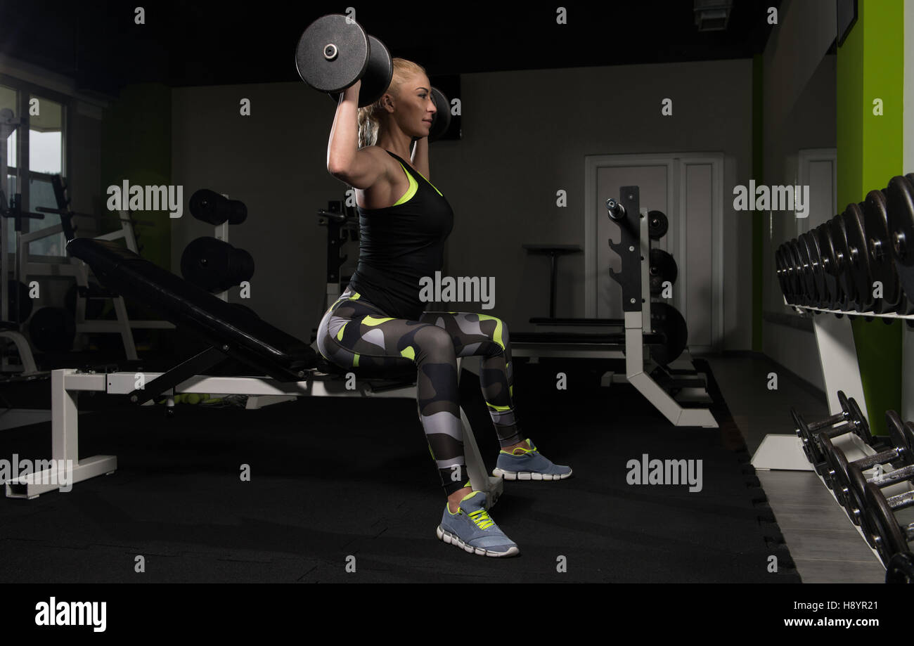 Woman Exercising Shoulders With Dumbbells In The Gym And Flexing ...