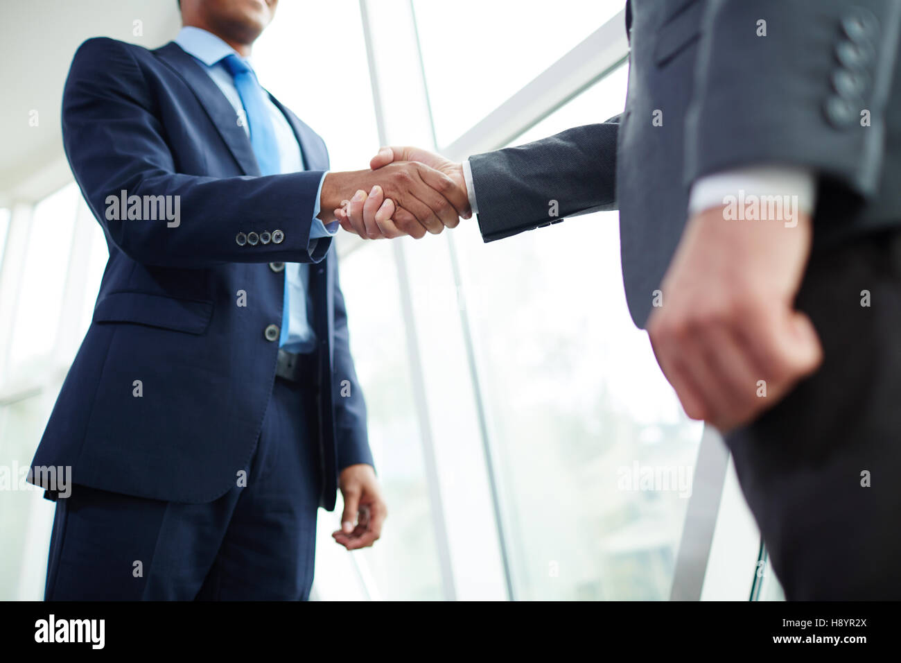 Salesman shaking hand of his client after signing contract Stock Photo ...