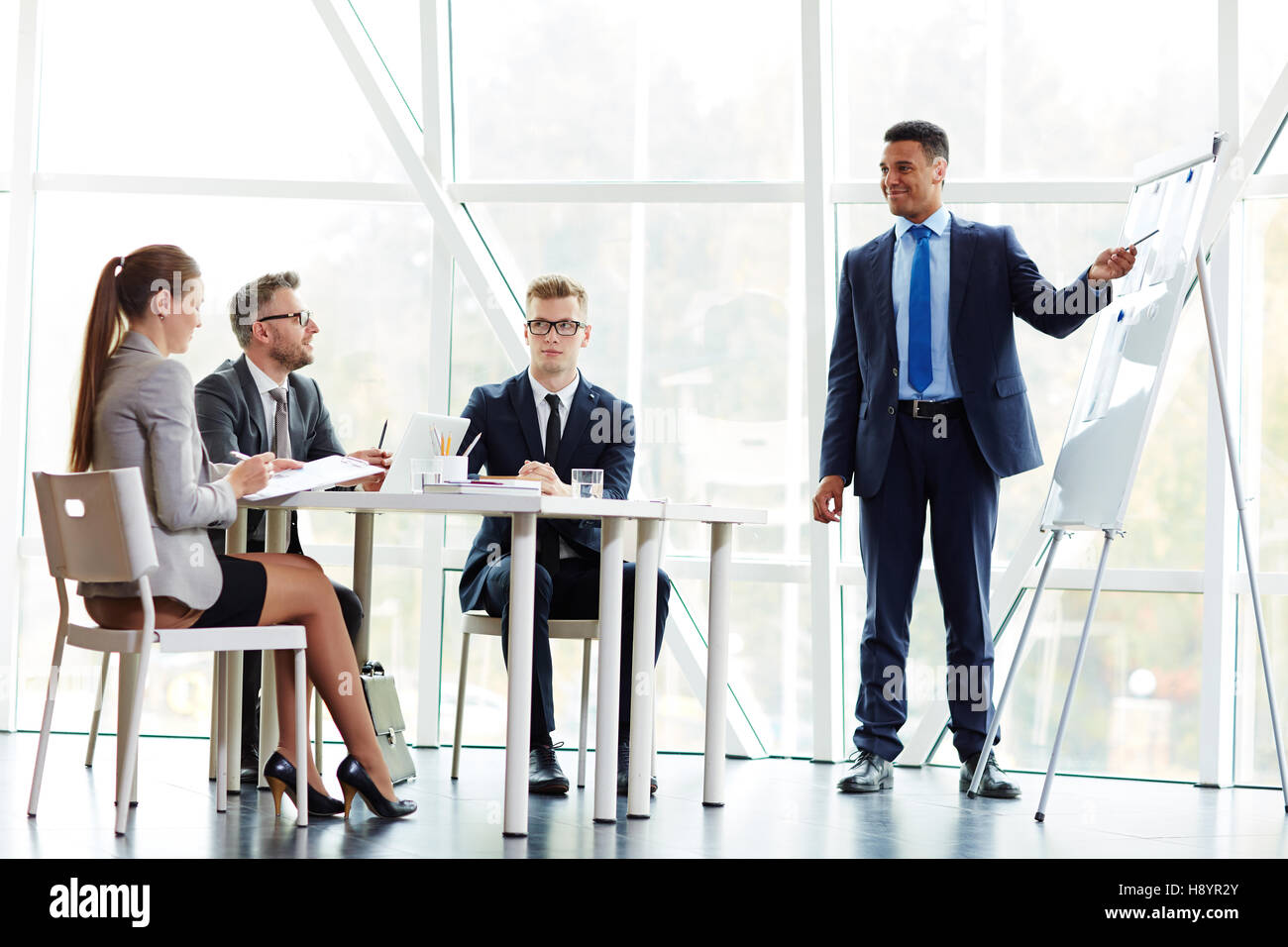 Young man explaining financial statistics to managers Stock Photo - Alamy