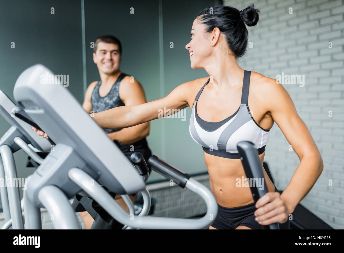 Active woman running on treadmill and talking to her trainer Stock ...