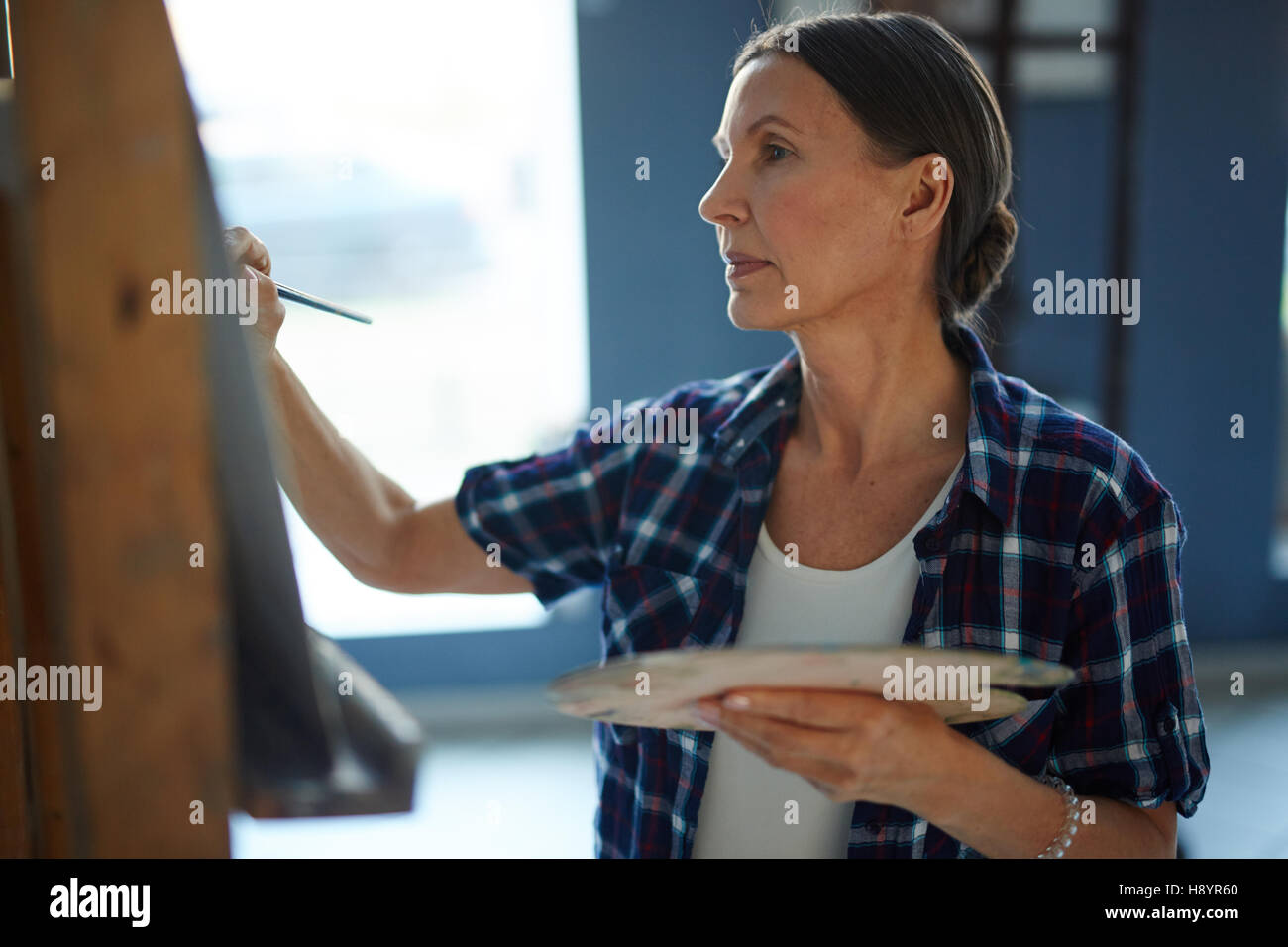 Mature woman drawing with watercolors in art studio Stock Photo - Alamy