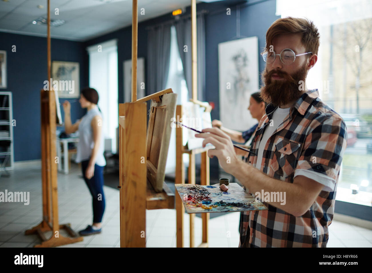 Talented guy painting on canvas with acrylic paints Stock Photo - Alamy