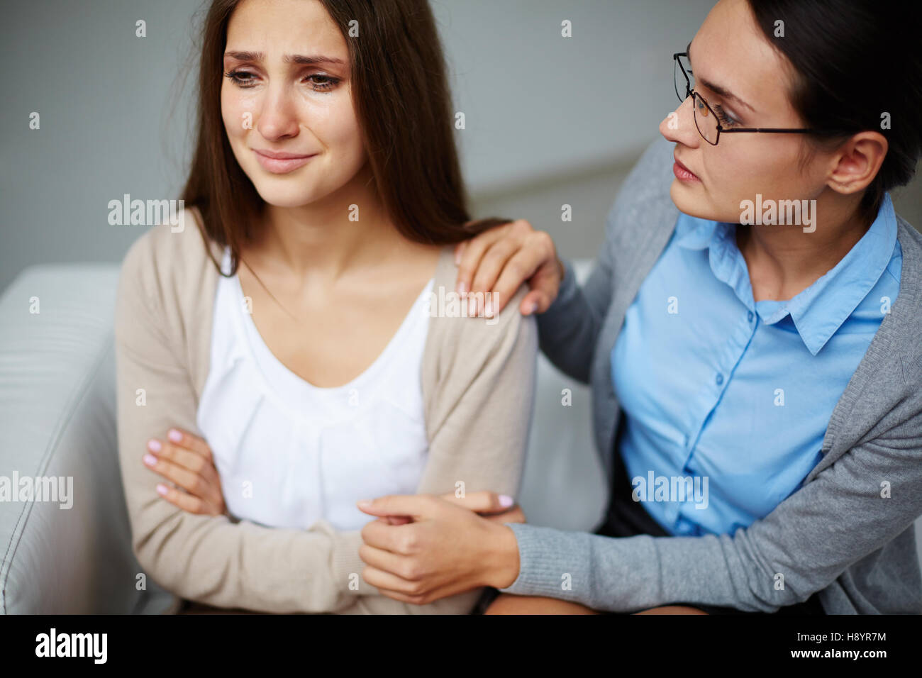 Psychologist supporting depressed girl during session Stock Photo - Alamy