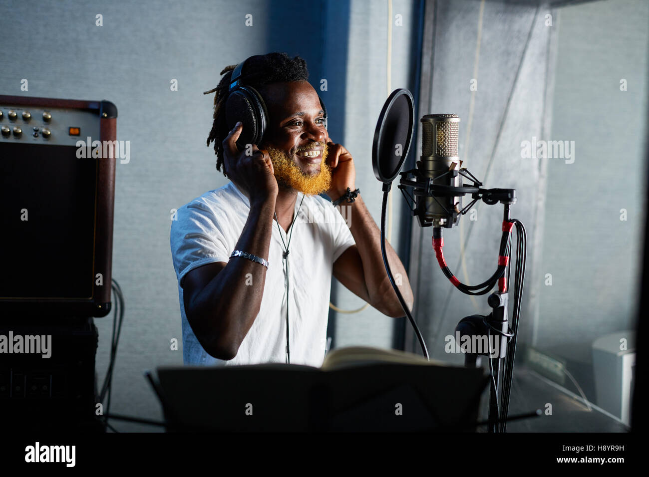 Happy young pop-singer recording his songs in studio Stock Photo - Alamy