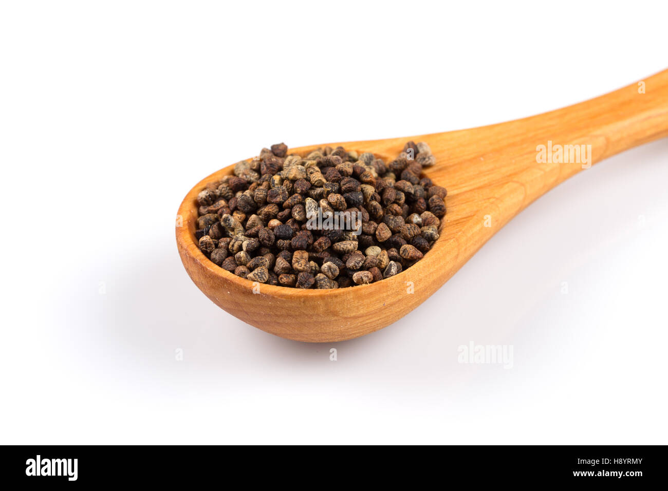 Decorticated cardamom seeds in a wooden spoon on white background Stock ...