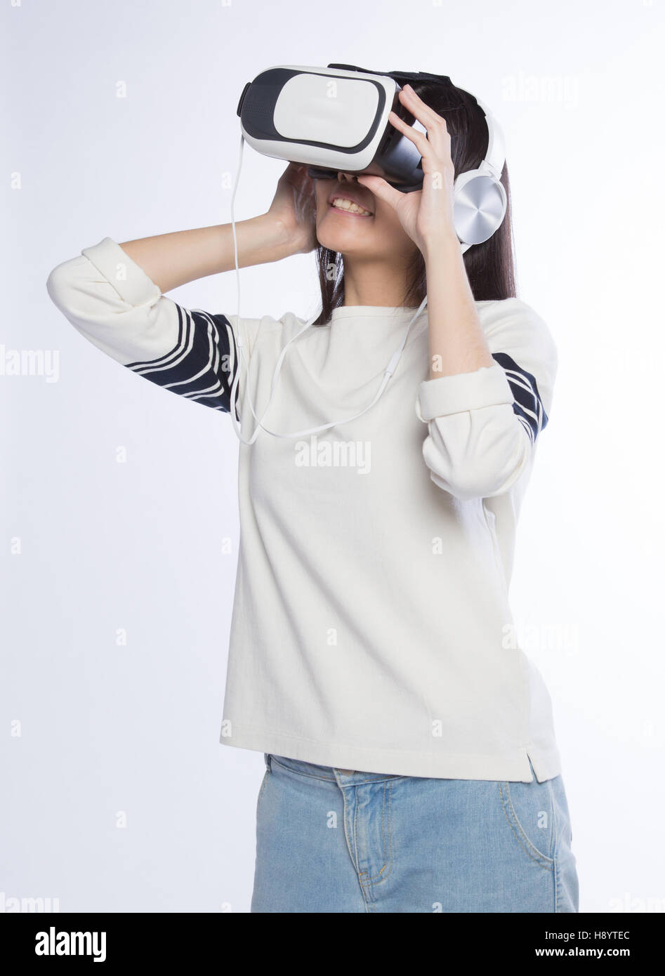 asian woman adjusting her VR headset with her hands, isolated white ...